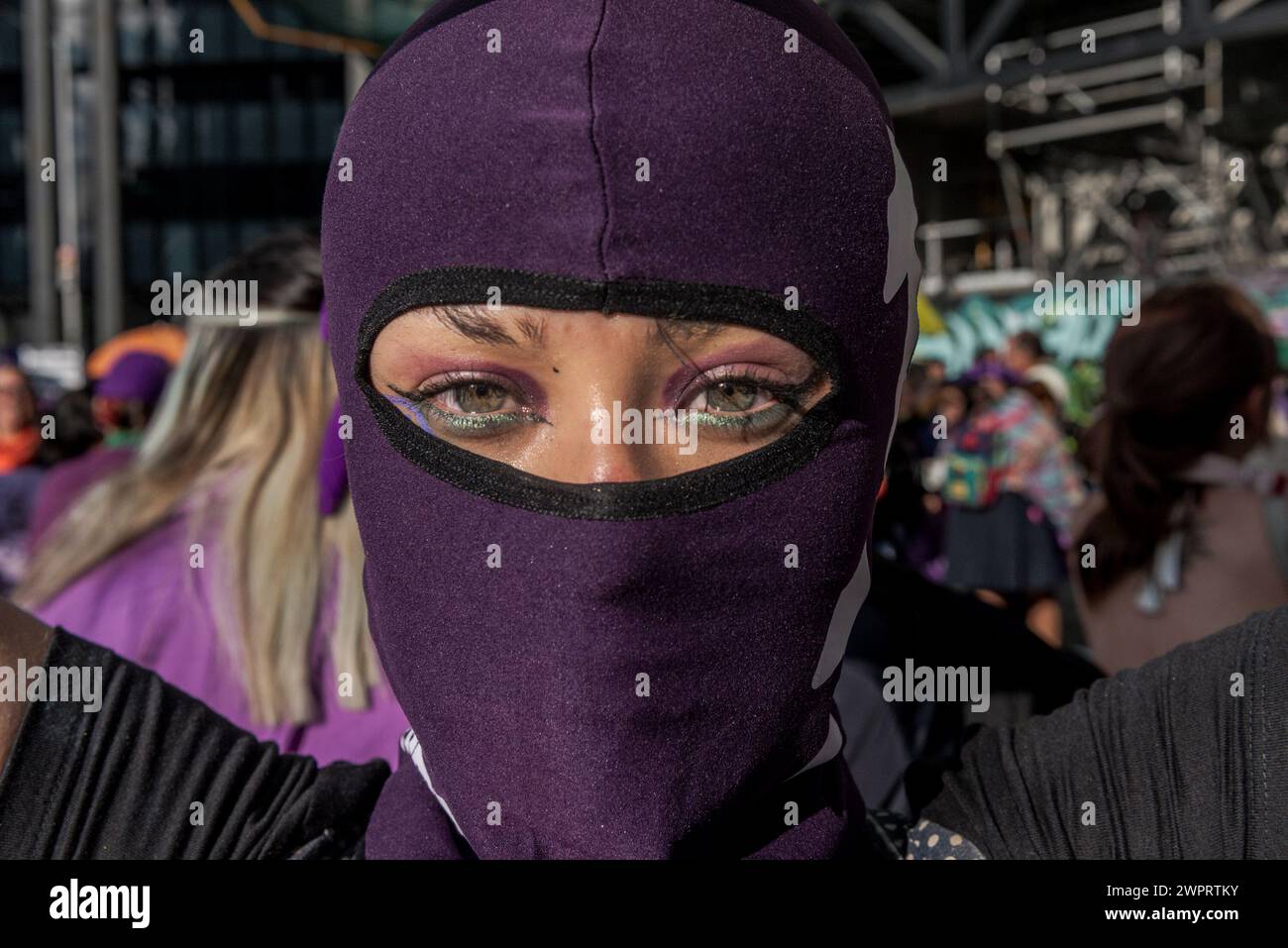 A masked woman is seen during the International Women's Day ...