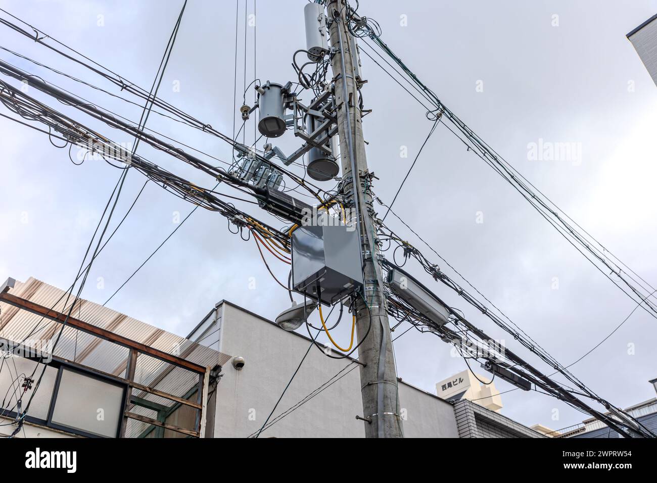 A utility pole with a lot of wires and a surveillance camera on it ...
