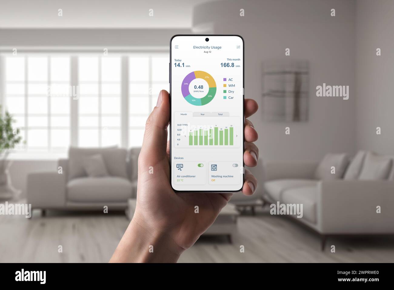 Hand holds smartphone with energy consumption app in living room ...