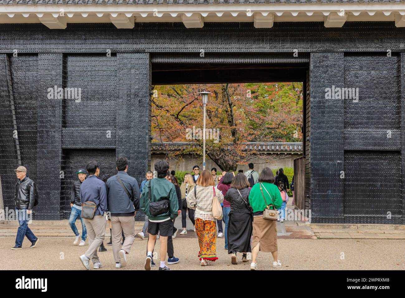 A group of people walking through a traditional Japanese gate Stock ...