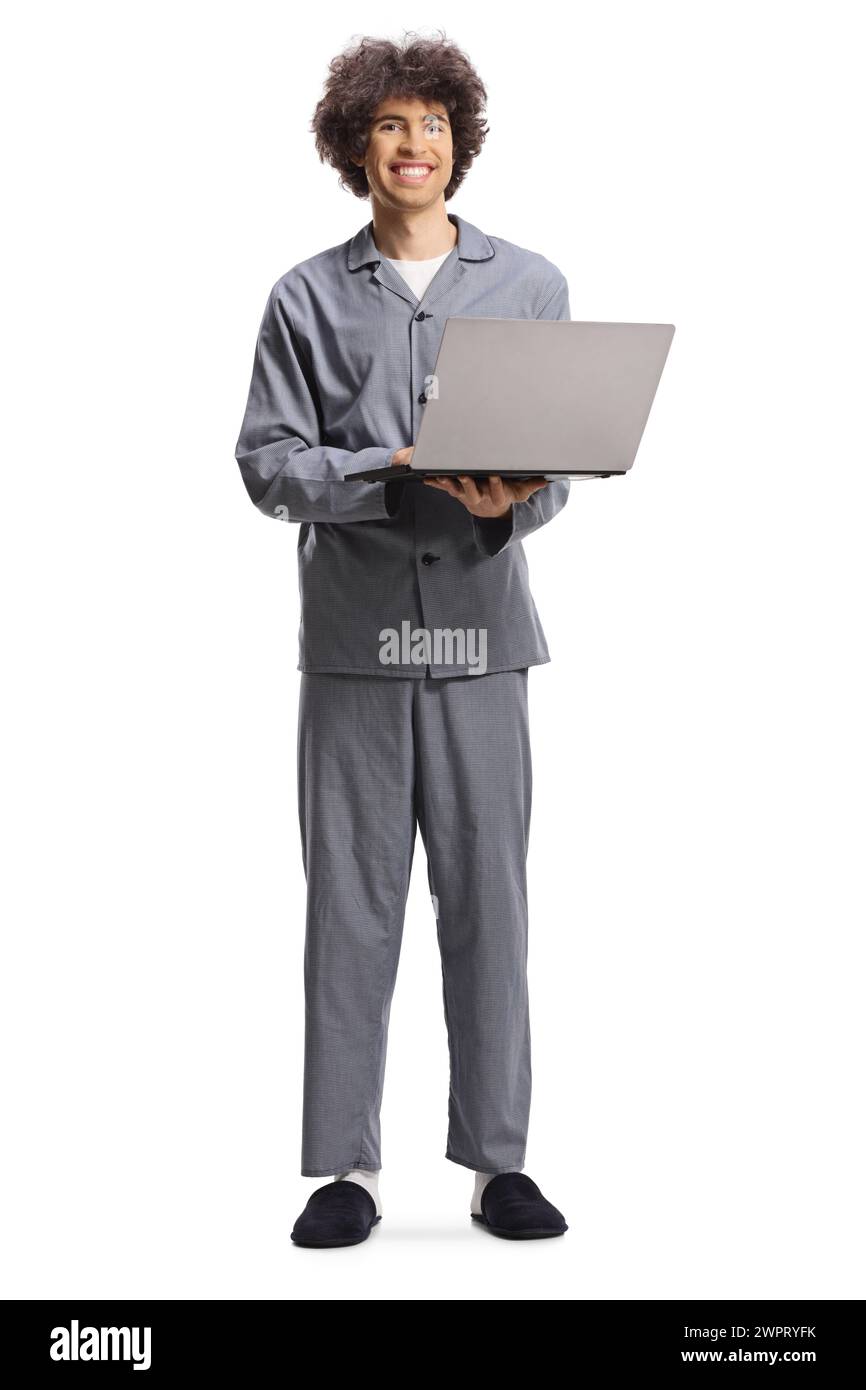 Full length portrait of a cheerful smiling guy in pajamas standing and ...