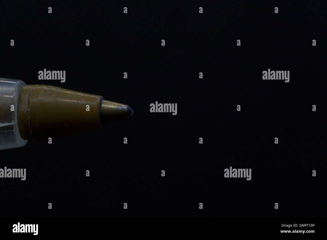 Detail of blue ink pen tip horizontally with black background and copy ...