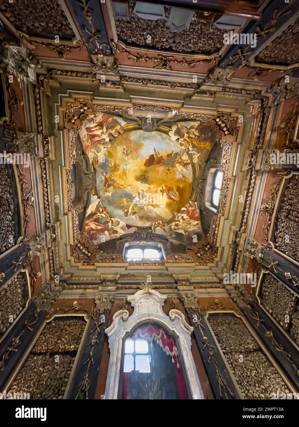 Arranged skulls, bones and paintings in the ossuary inside Chiesa di ...