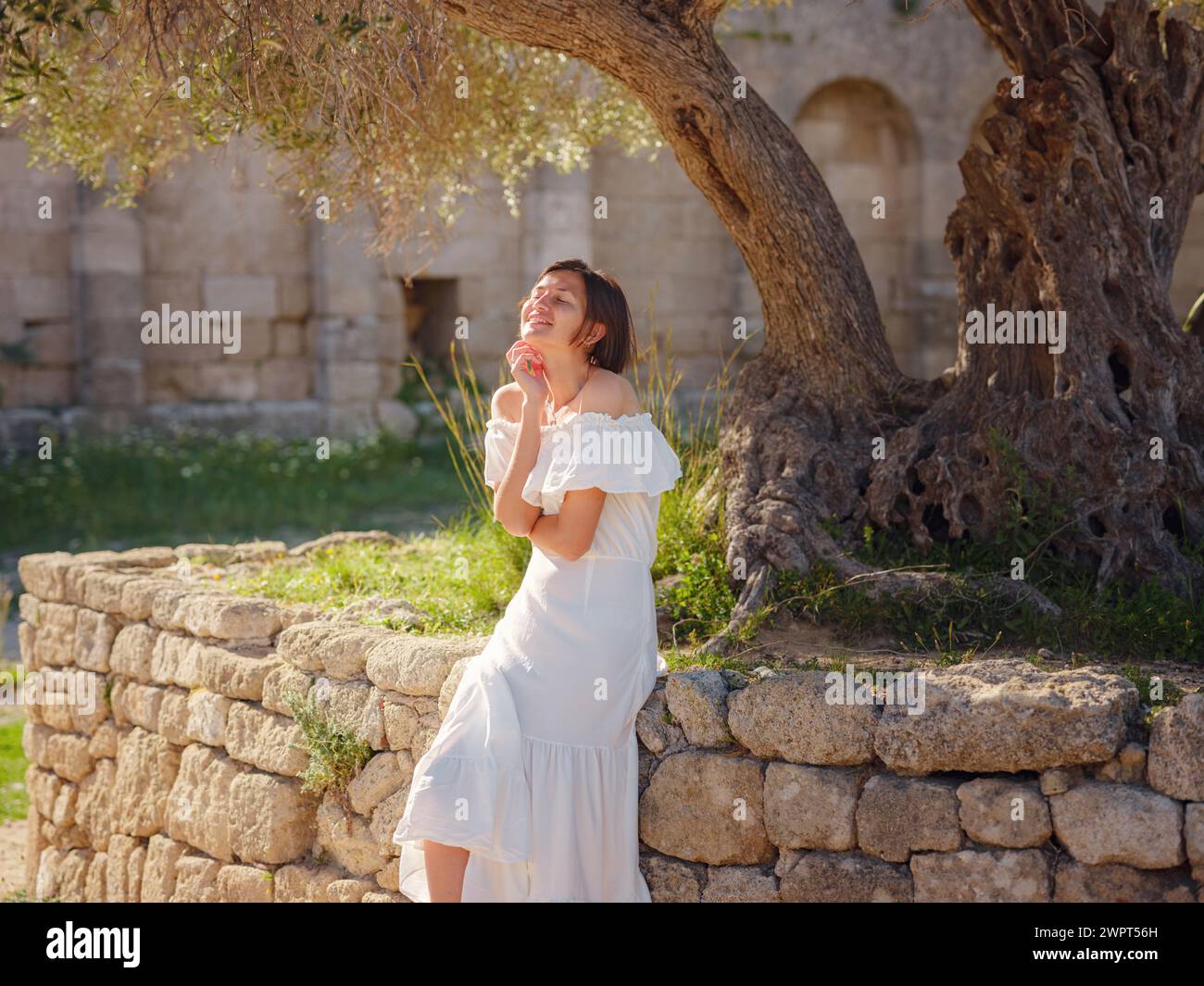 Beautiful Asian young woman in white dress outdoor. Acropolis of Rhodes ...