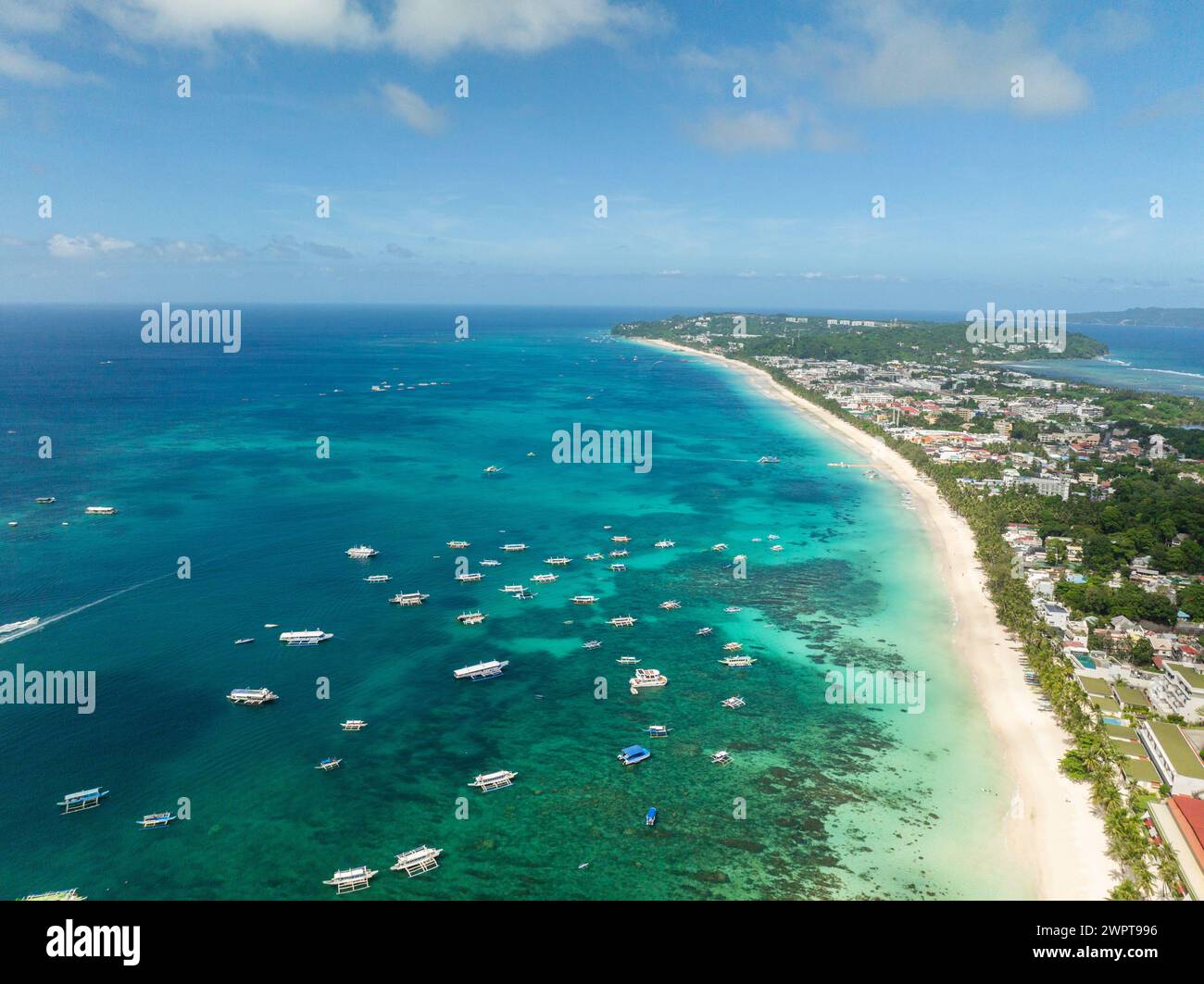 Beautiful aerial view of white sand beach and boats over clear water in ...