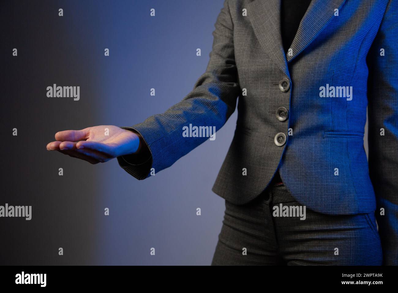 Part of a business woman with her arm extended forward and palm up ...