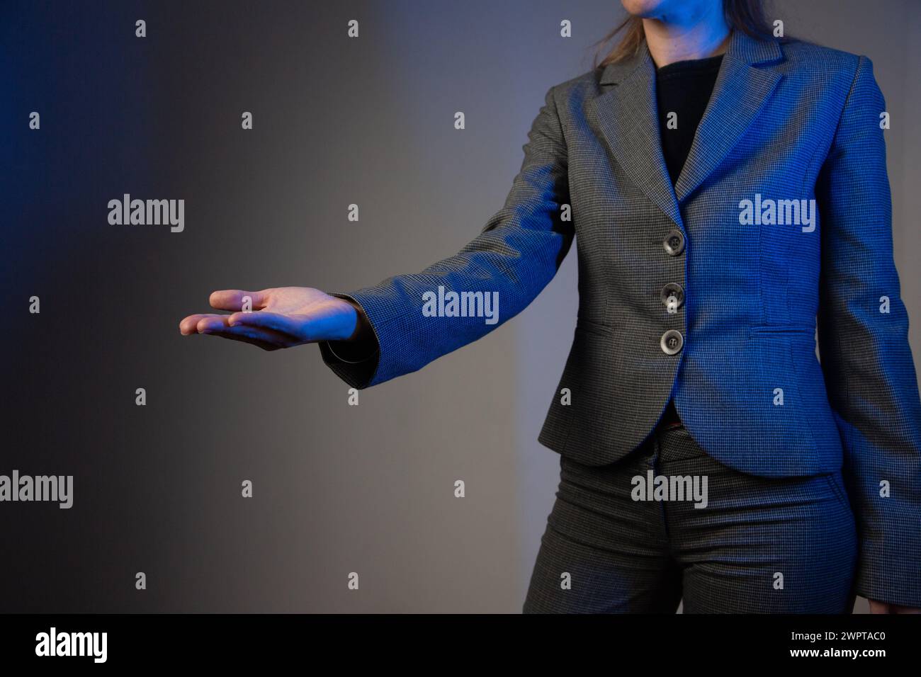 Part of a business woman with her arm extended forward and palm up ...