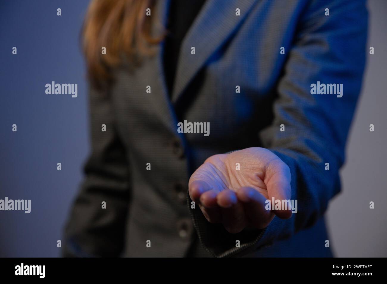 Part of a business woman with her arm extended forward and palm up ...