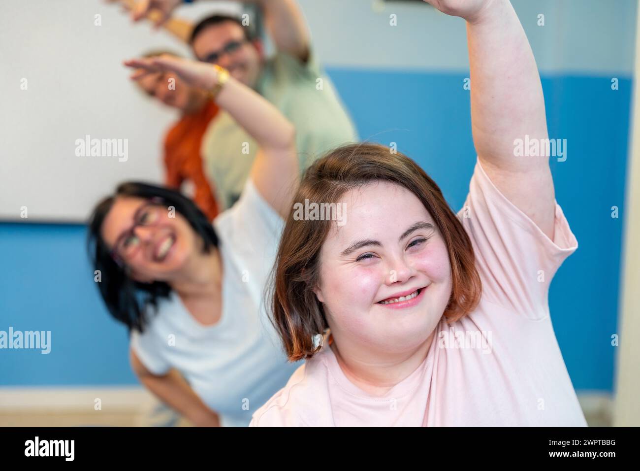 Happy group of people with special needs enjoying gymnastics stretching ...
