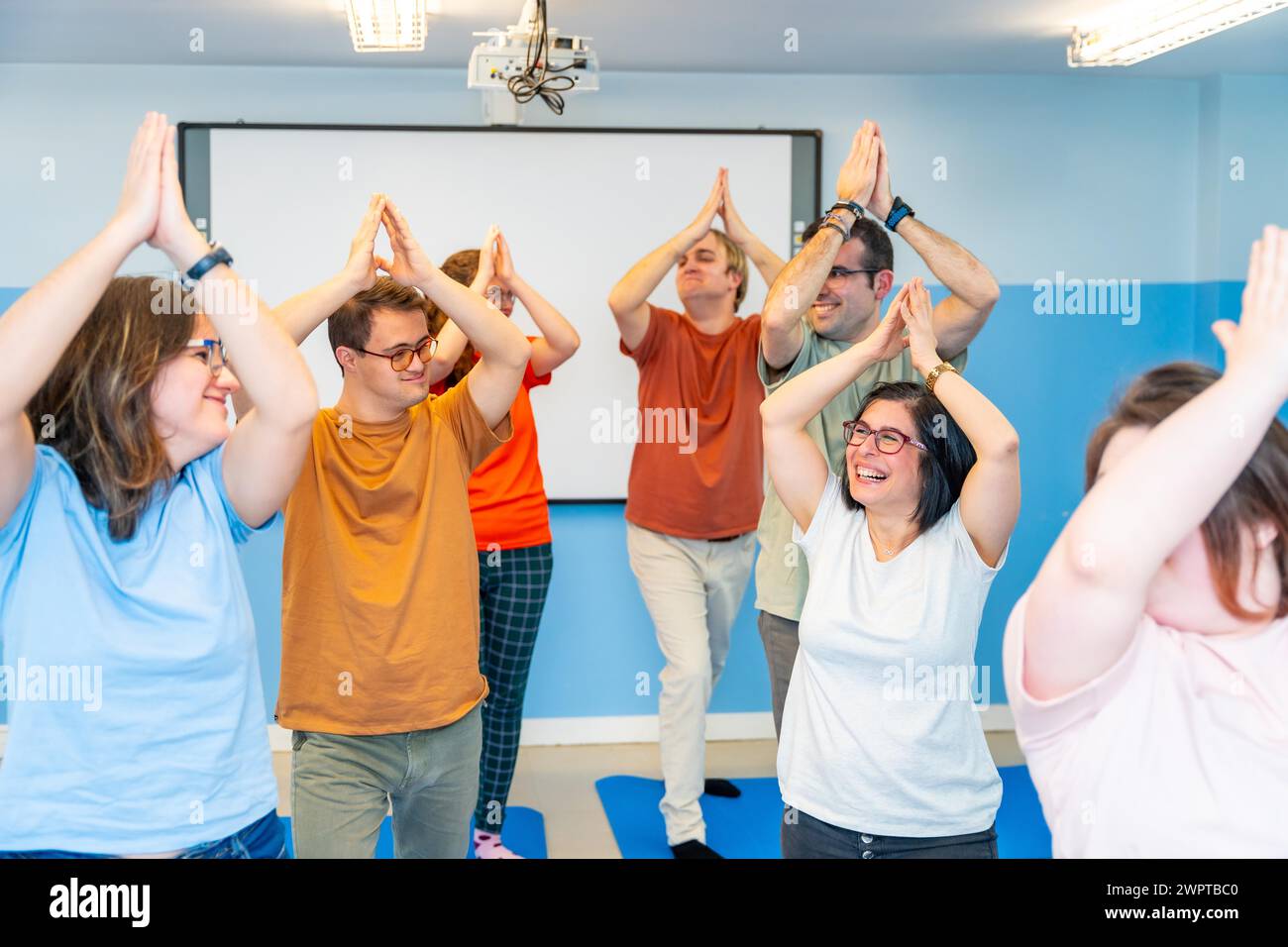 Happy disabled people having fun during yoga class together in a gym ...