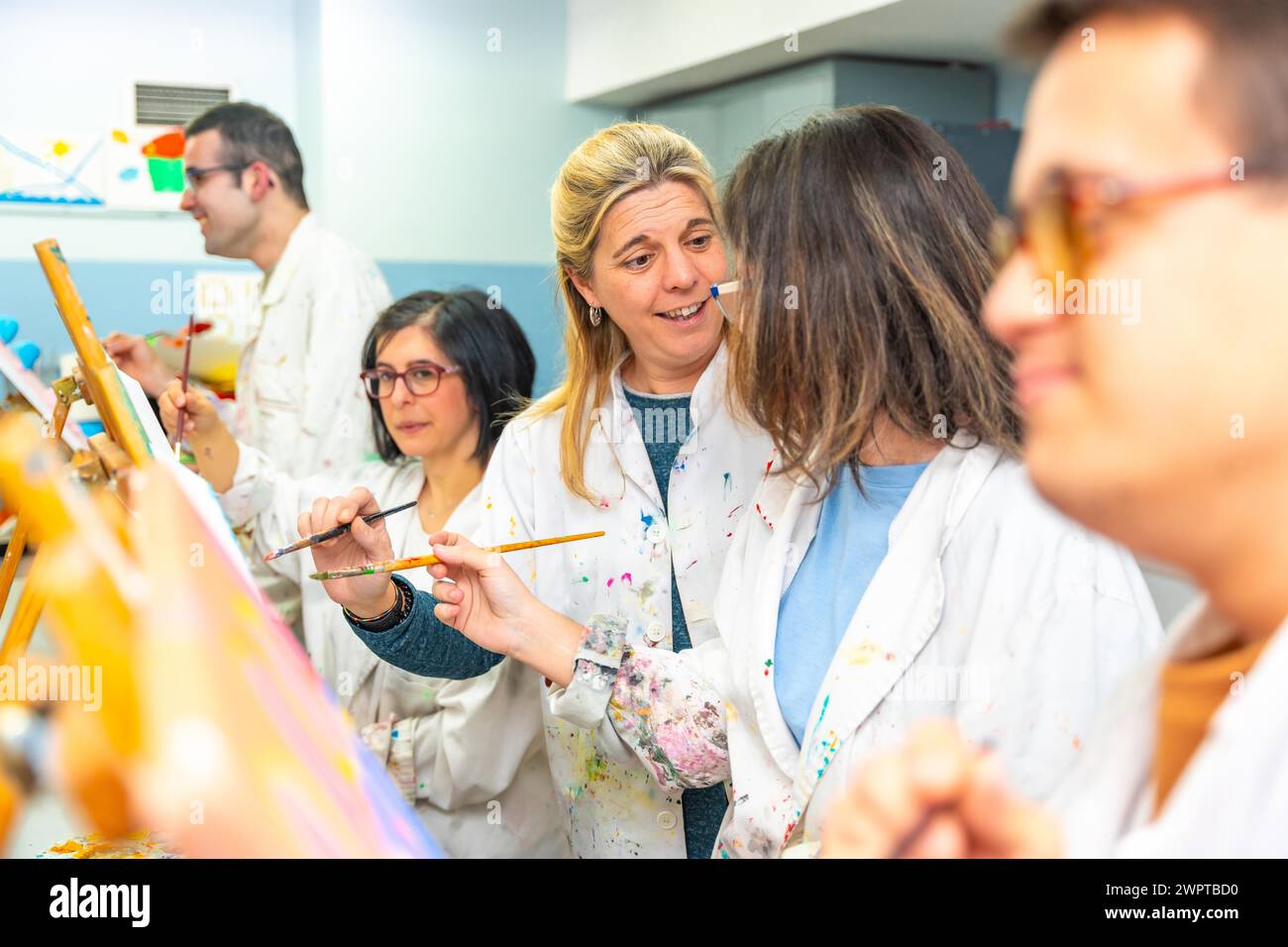 Art painting class of mental disabled students using brushes to paint ...