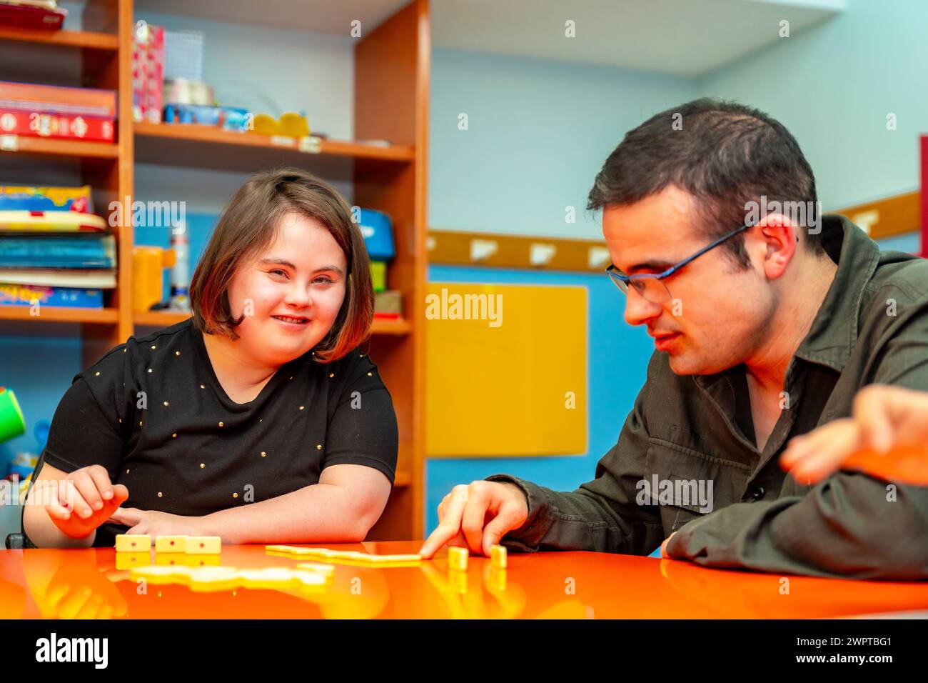 People with special needs playing board skill games in a day center ...