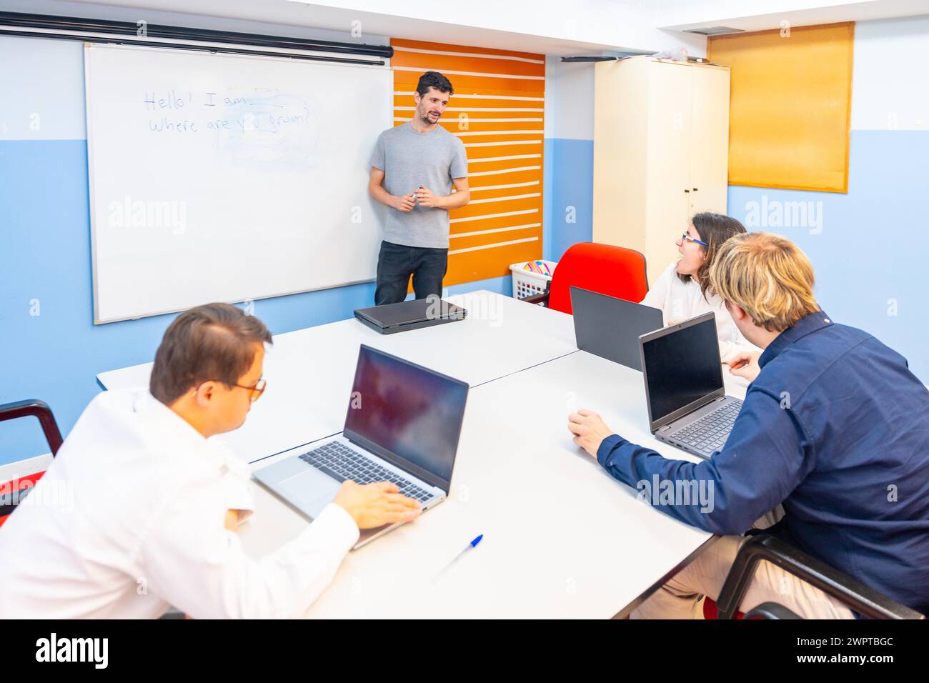 People with special needs attending a IT class using laptop while ...
