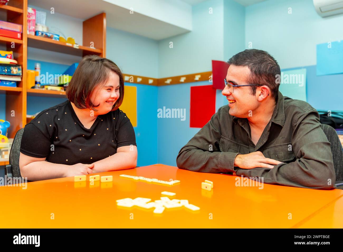 Woman with down syndrome and disabled man playing board games in a day ...