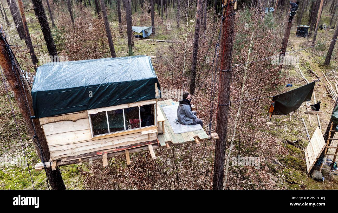 A climate activist sits in a tree house in the Gruenheide forest. The ...
