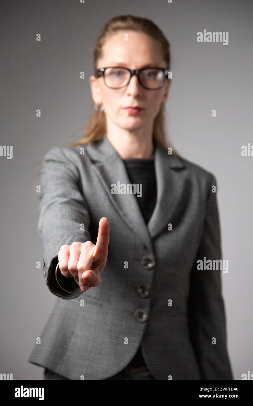 Portrait of a business woman in glasses with her arm extended forward ...
