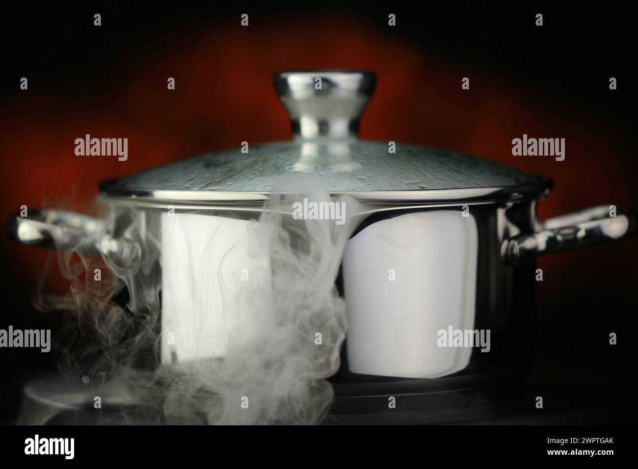 steam over cooking pot on a red background Stock Photo - Alamy