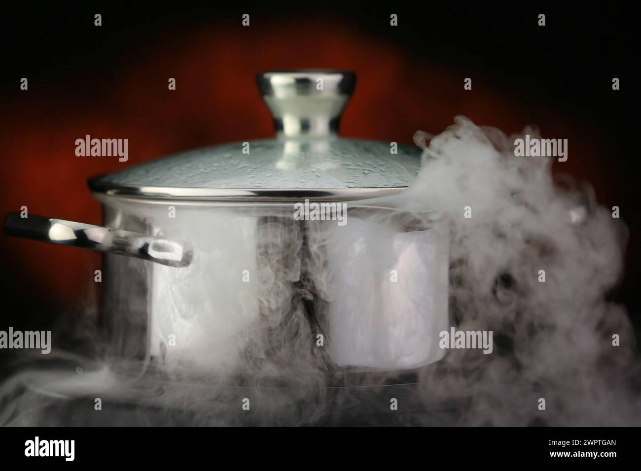 steam over cooking pot on a red background Stock Photo - Alamy