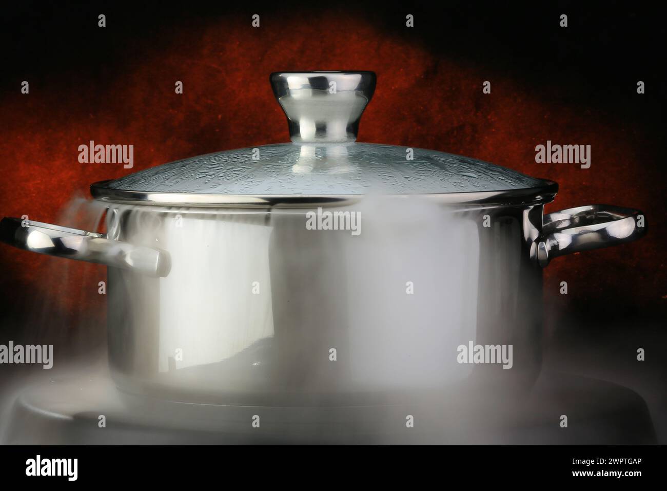 steam over cooking pot on a red background Stock Photo - Alamy
