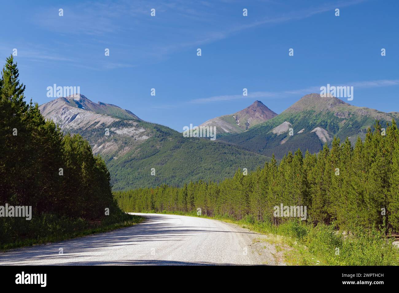 Narrow road without traffic, rugged mountains, wilderness, Stewart ...