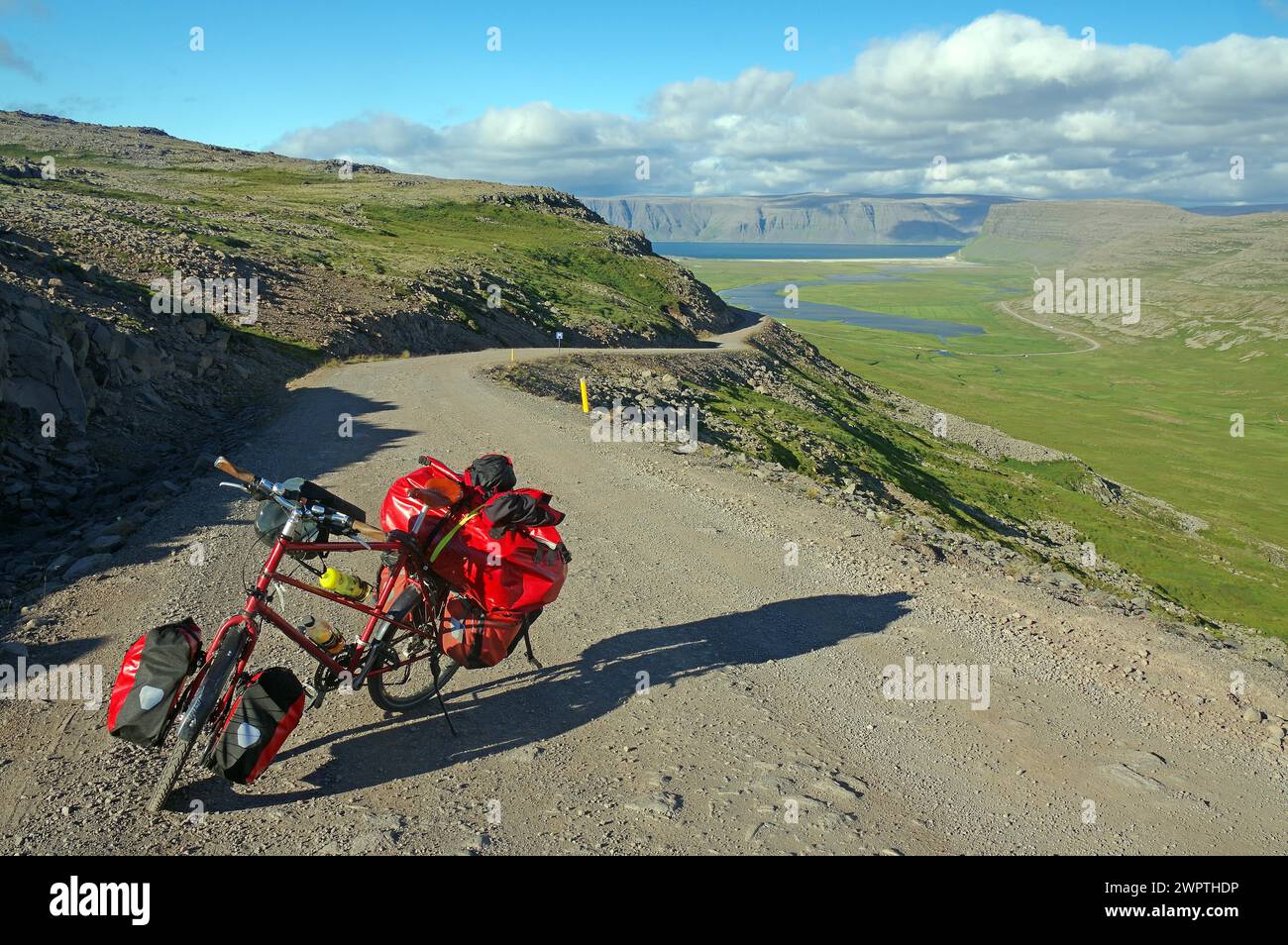 Packed bike standing on a gravelled track leading out into a wide ...