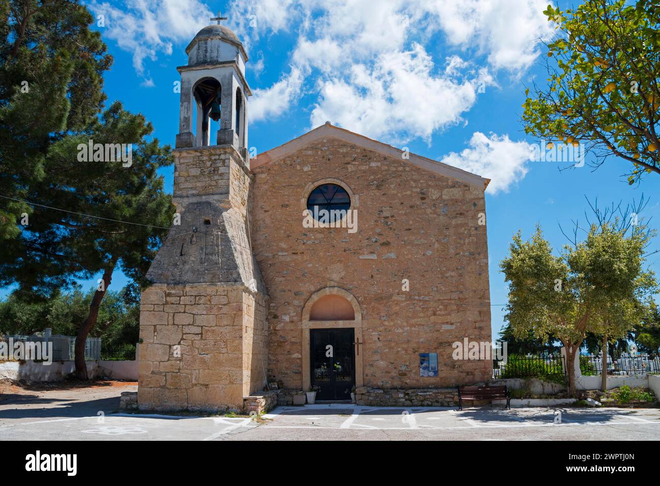 Ancient stone church with a free-standing bell tower under a bright ...
