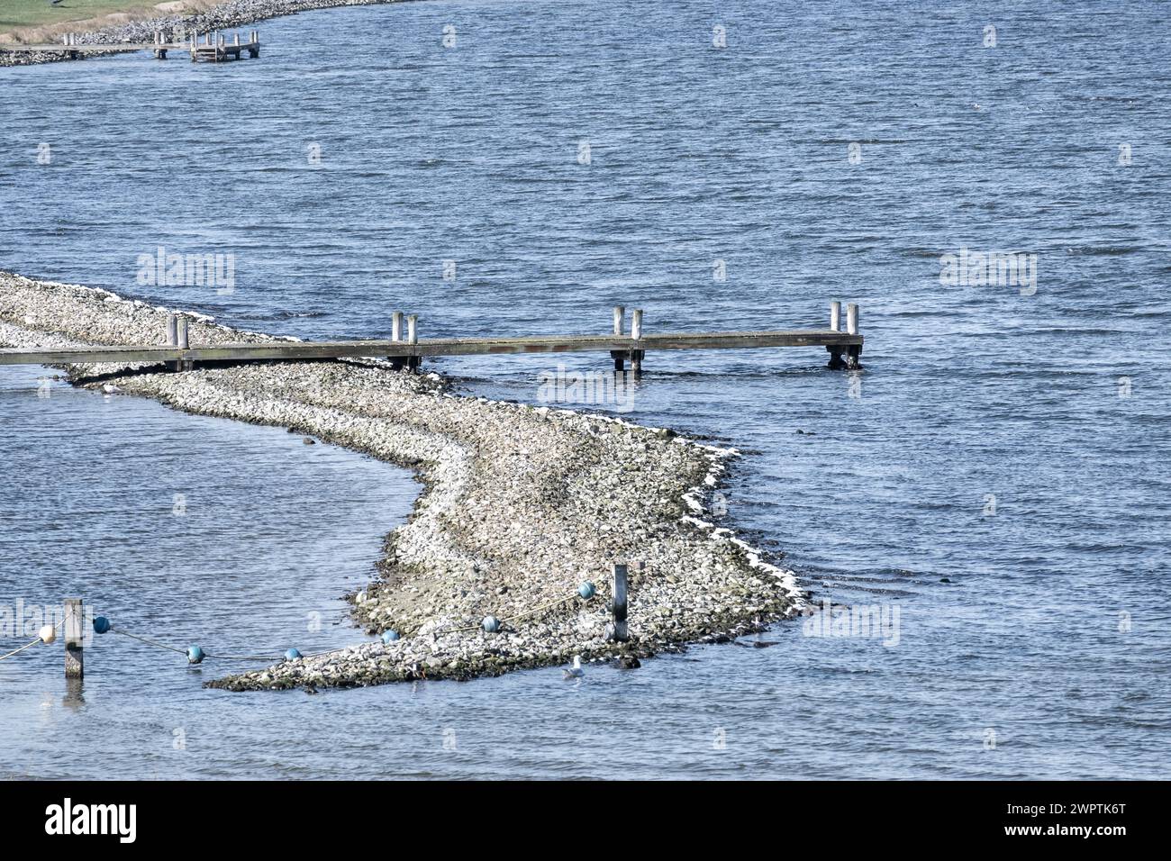 A calm body of water with a small jetty and curved shoreline, Veere ...