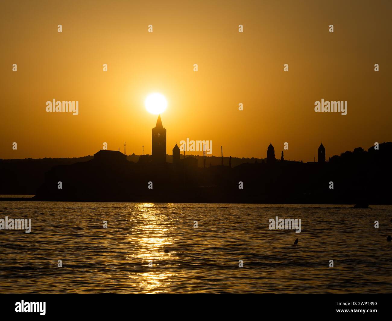 Sunset, silhouette of the church towers of Rab, town of Rab, island of ...