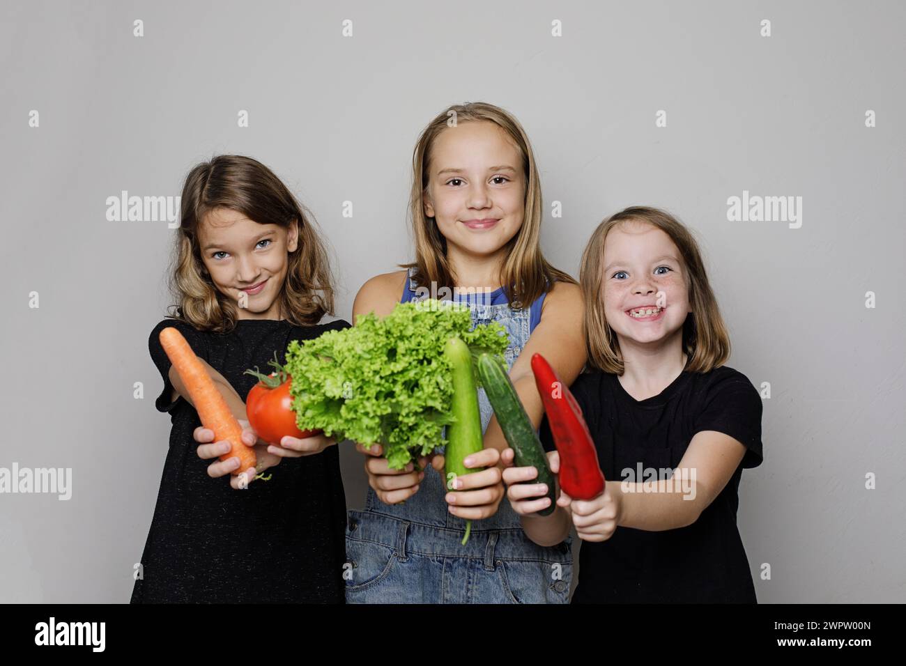 Cute smiling children with vegetables on white studio wall banner ...