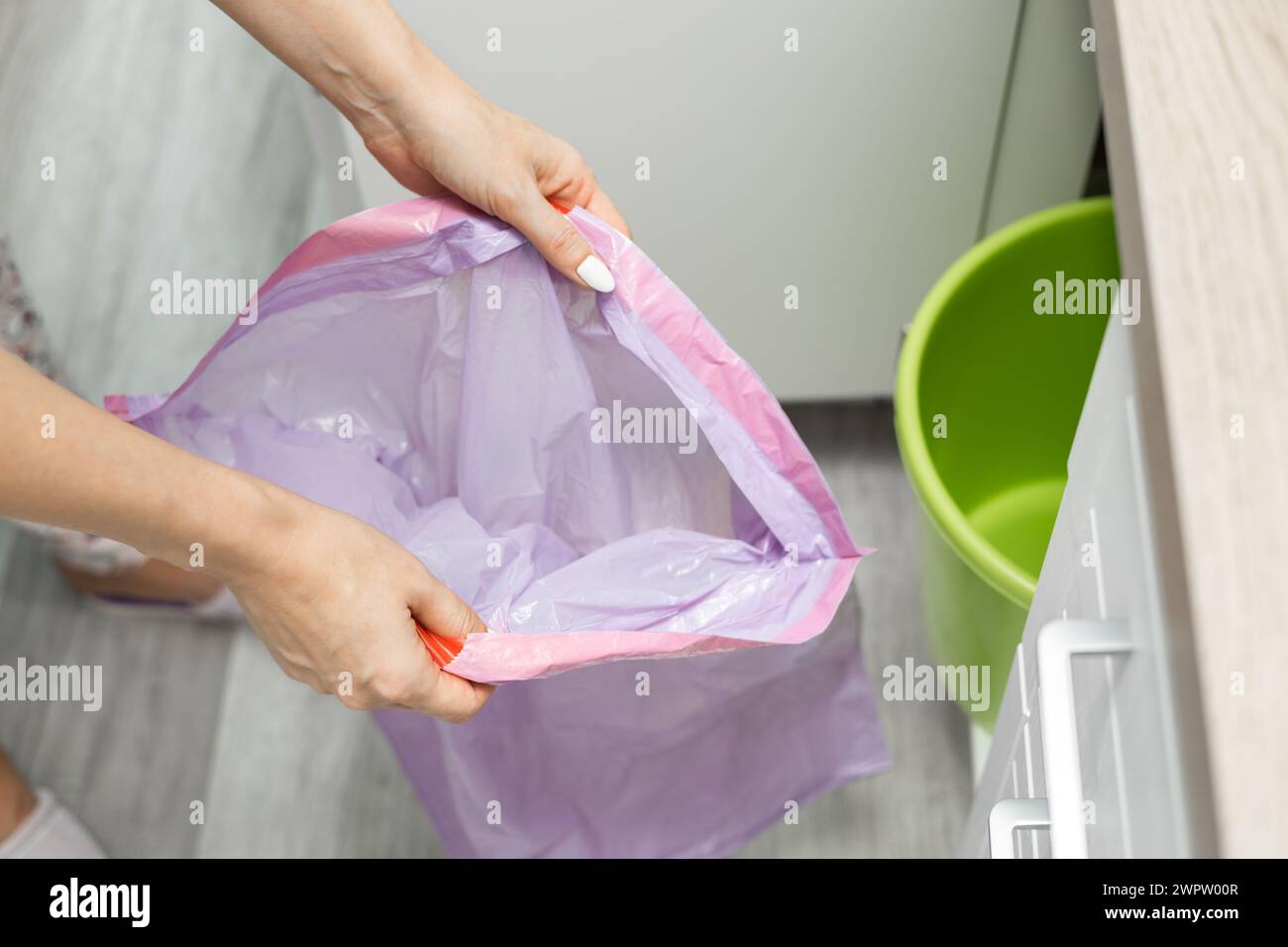 a man changes a garbage bag in a bucket. woman changing trash bag ...