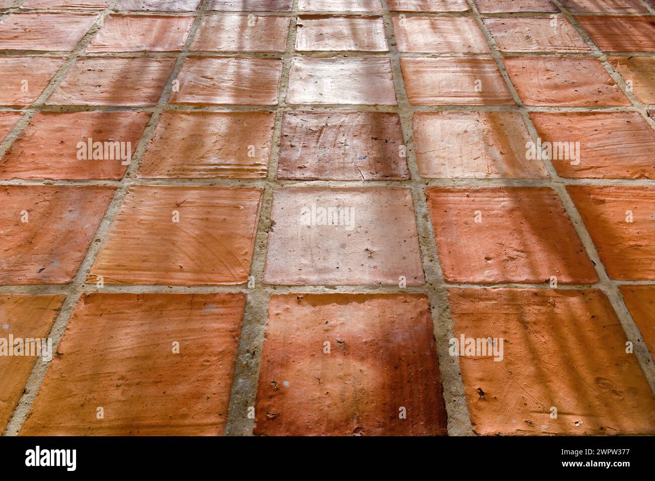 Perspective view of a rustic clay floor illuminated by the light of ...