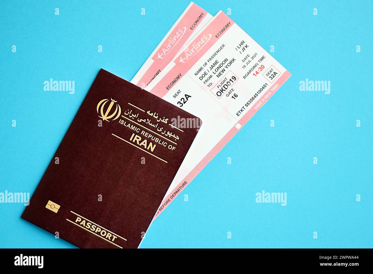 Red Islamic Republic of Iran passport with airline tickets on blue ...