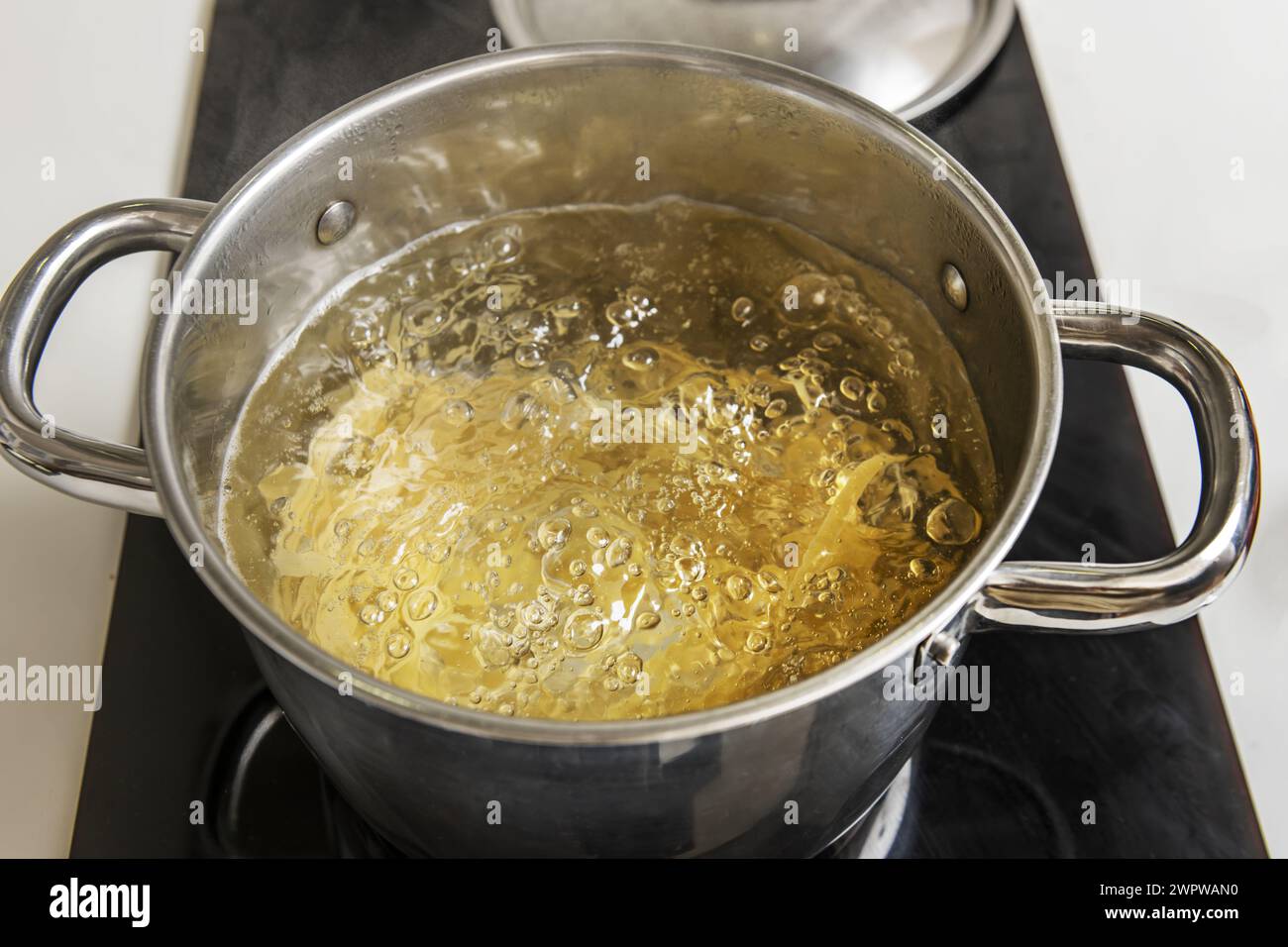 Wheat noodles cooked inside a stainless steel pot filled with boiling ...
