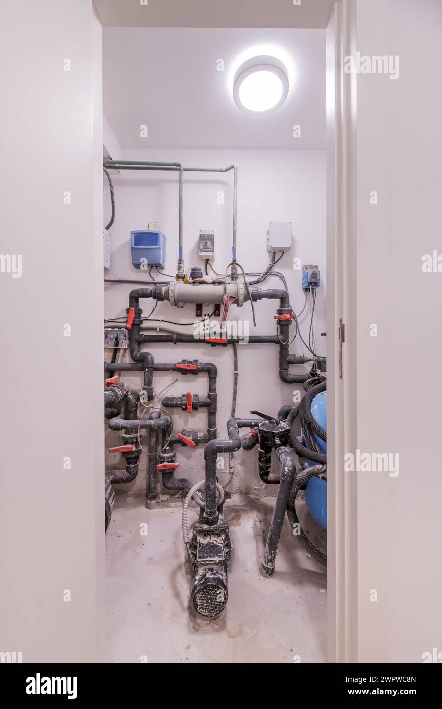 A boiler room with water distribution pipes on the ground floor of a ...