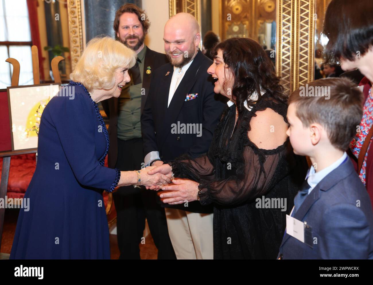 Queen Camilla shakes hands with a guest during a reception for the BBC's 500 Words Finalists at ...