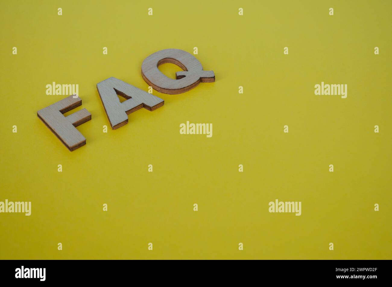 FAQ wooden letters on yellow background. Question and Answer concept ...