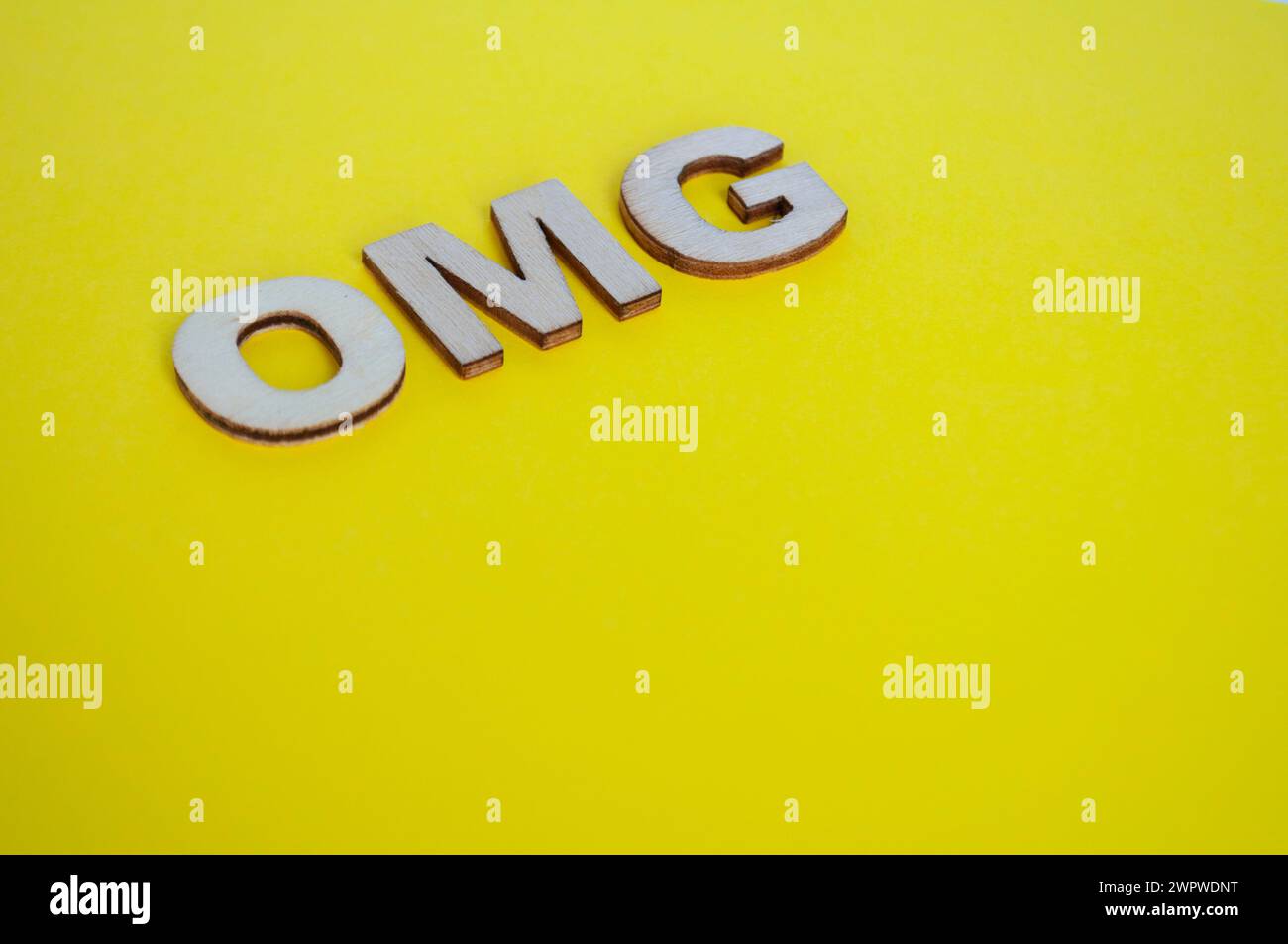 OMG wooden letters representing Oh My God on yellow background Stock ...