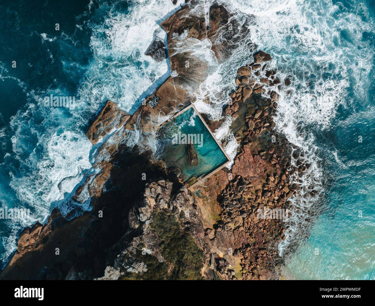 Aerial view early morning light with ocean waves flowing over rocks ...