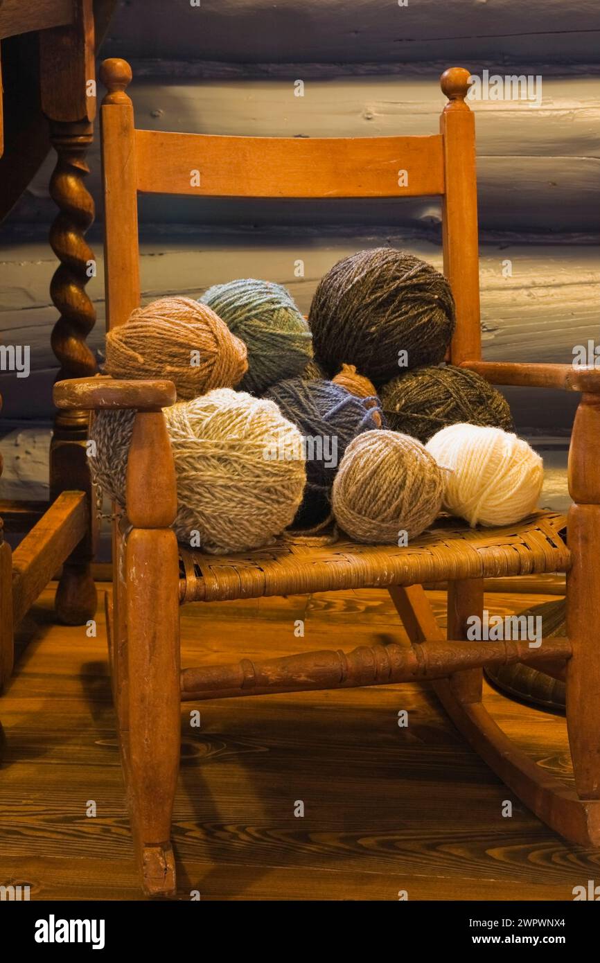 Balls of kitting yarn on old miniature weaved seat wooden rocking chair ...