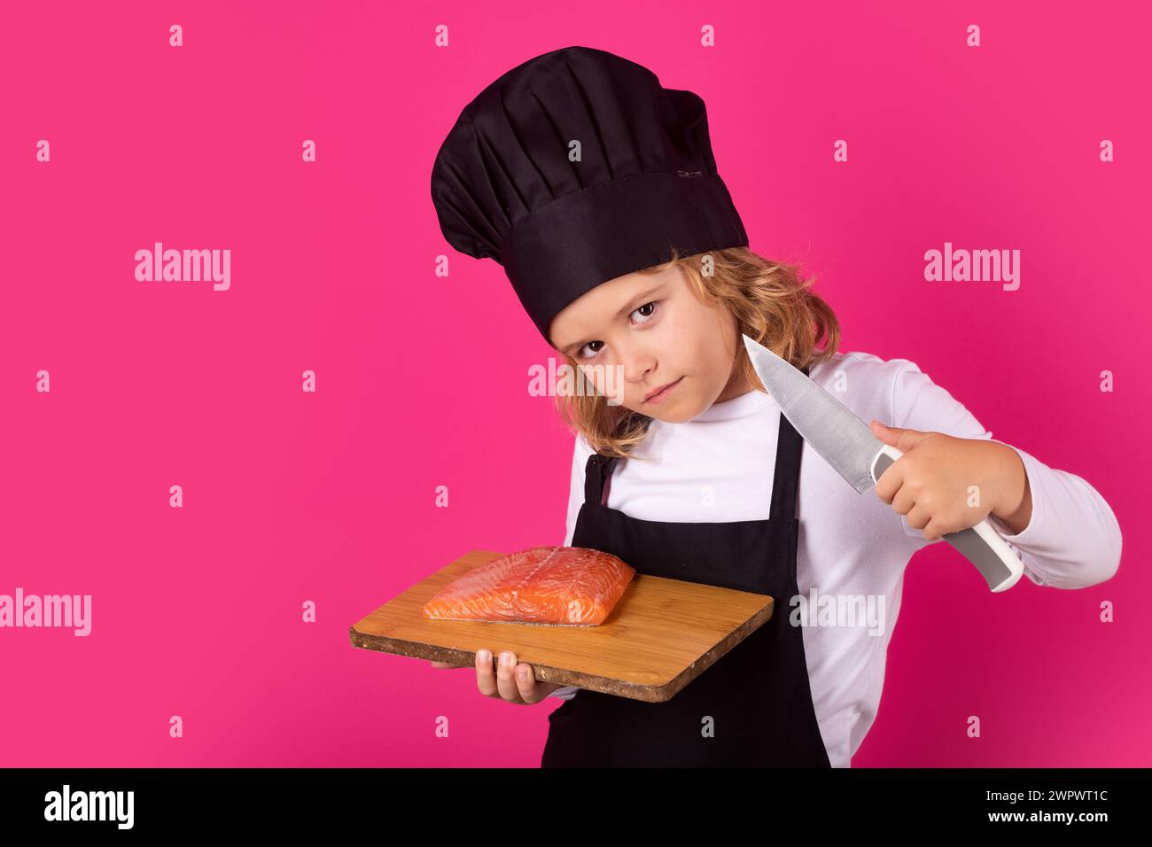 Child cook hold cutting board with fish salmon steak and knife. Cooking ...