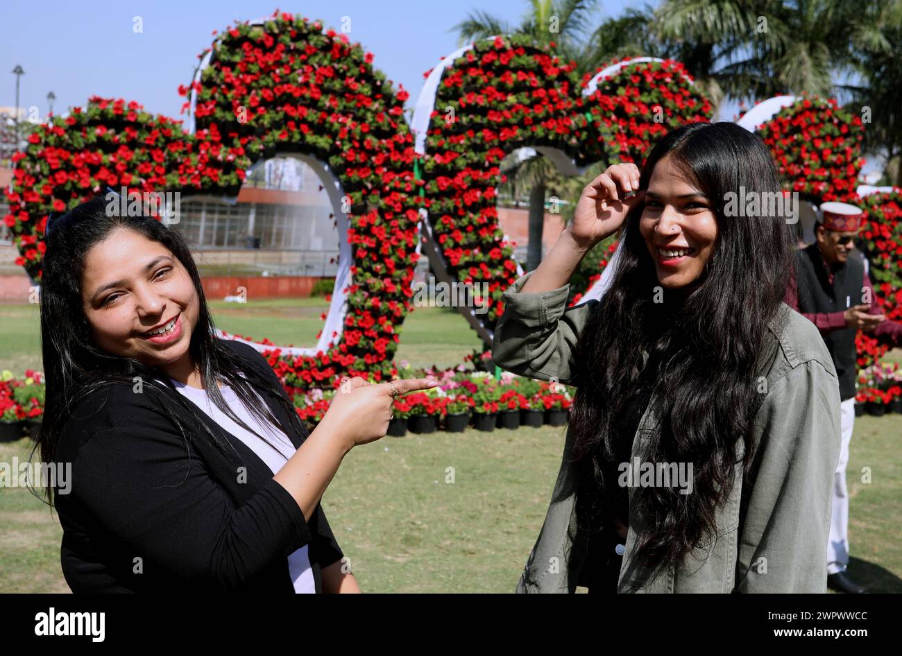 New Delhi, India. 09th Mar, 2024. Visitors pose with blooming flowers during the Flower Festival ...