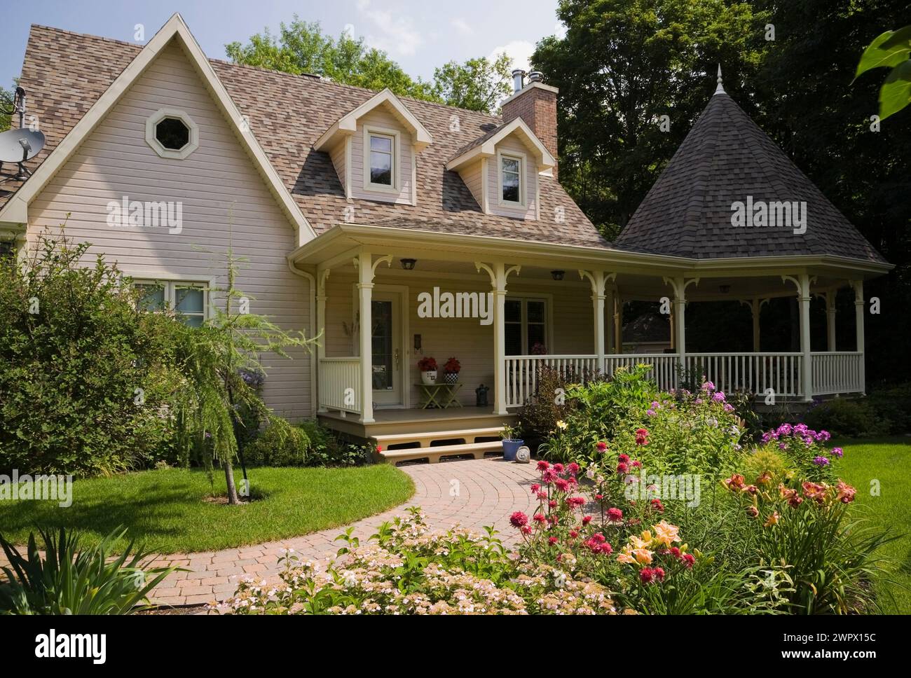 Two story beige and brown country home with gazebo and red Monarda ...