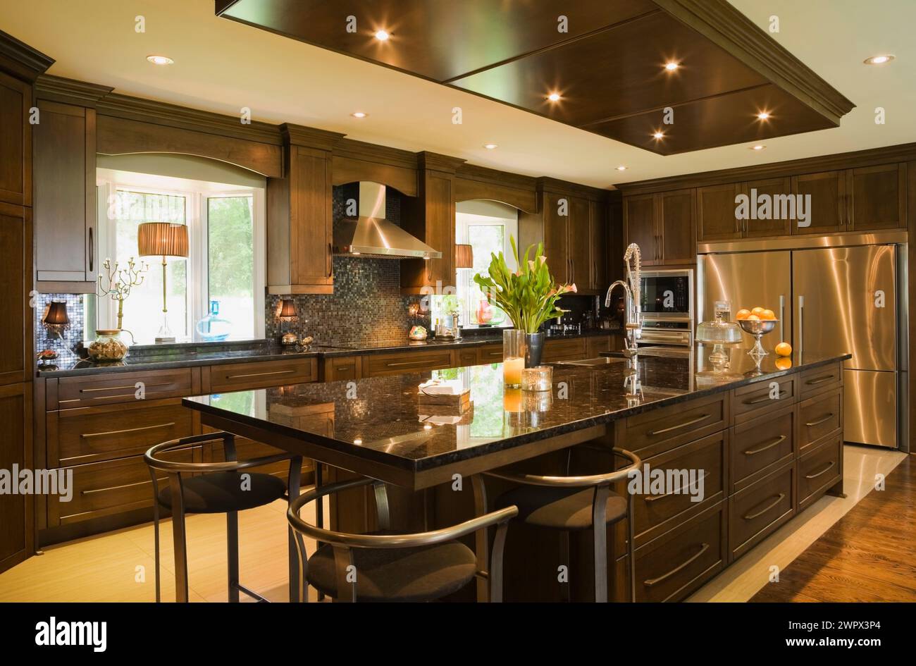 Granite countertop island in spacious kitchen with brown stained wooden ...