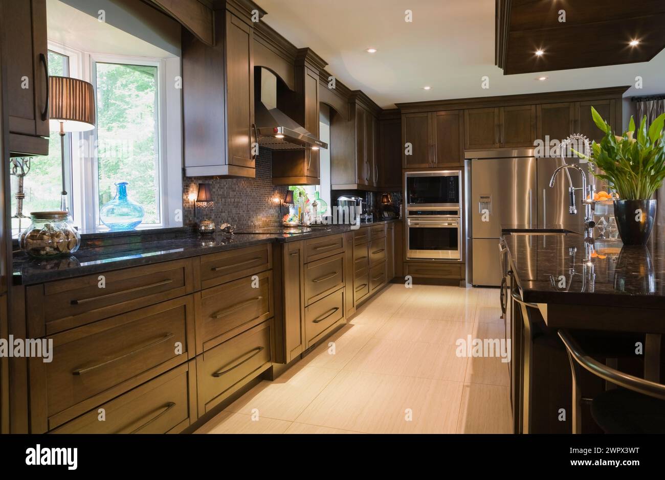 Granite countertops in spacious kitchen with brown stained wooden ...