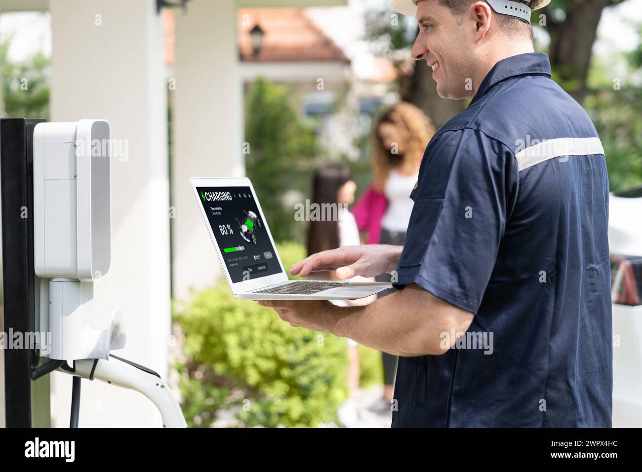 Qualified technician working on home EV charging station installation ...