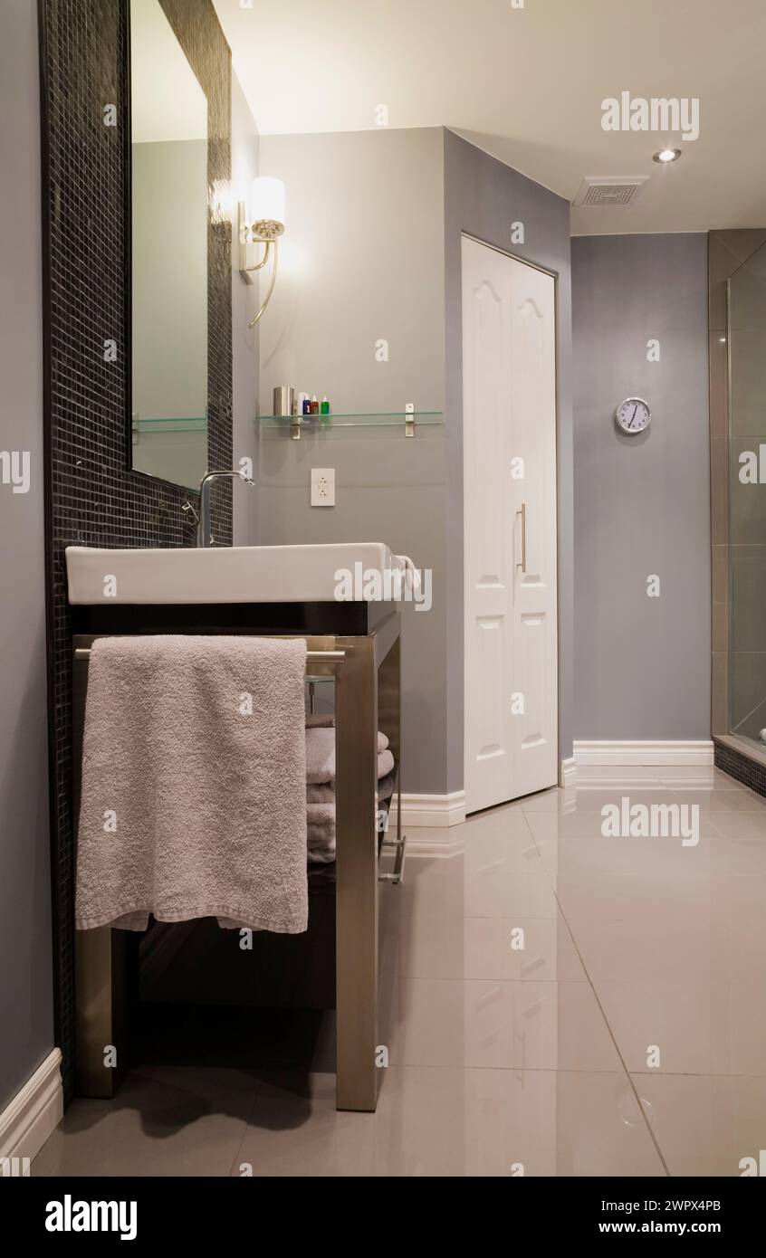 Stainless steel vanity and white rectangular sink in bathroom with ...