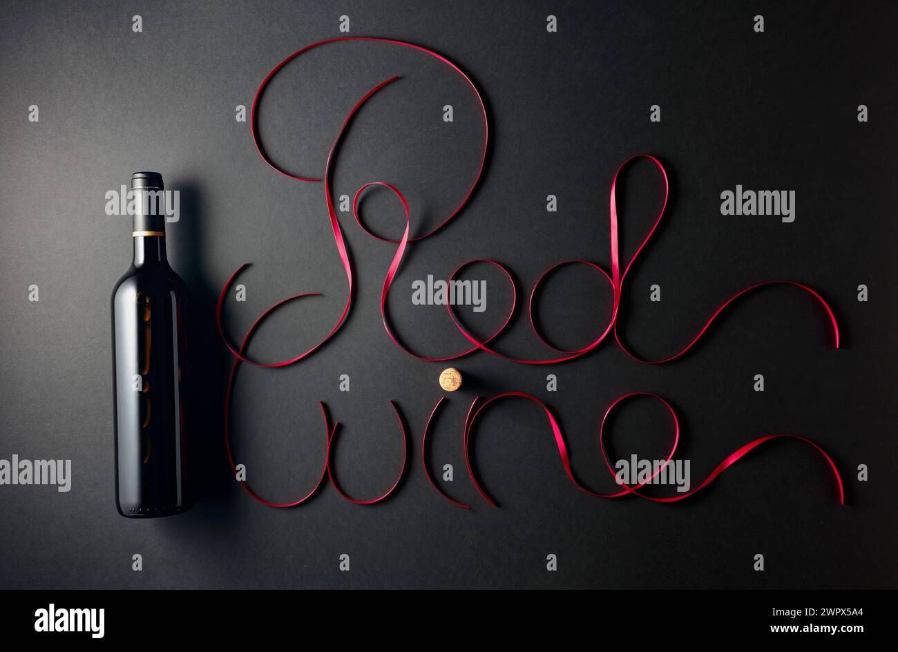 Bottle of red wine with red satin ribbons. Thin satin ribbon in the ...