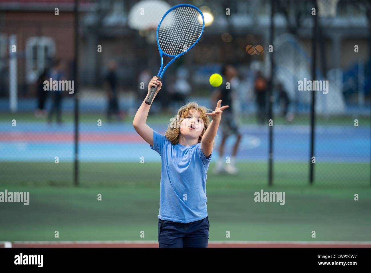 Cute Kid play tennis. Little kid hit tennis ball with tennis racket. Active exercise for kids ...