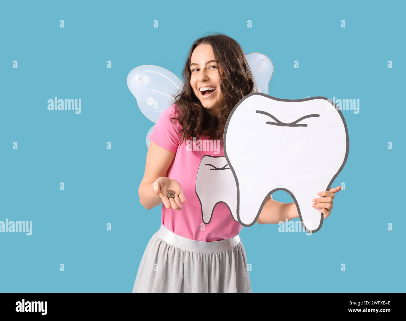 Tooth Fairy with paper figure and coins on blue background Stock Photo ...