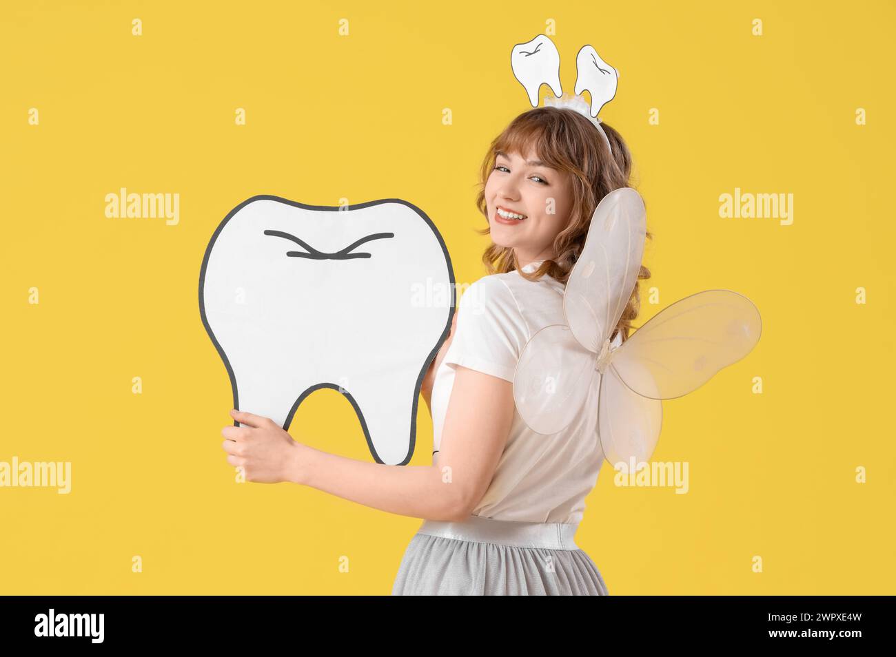 Tooth Fairy with paper figure on yellow background Stock Photo - Alamy